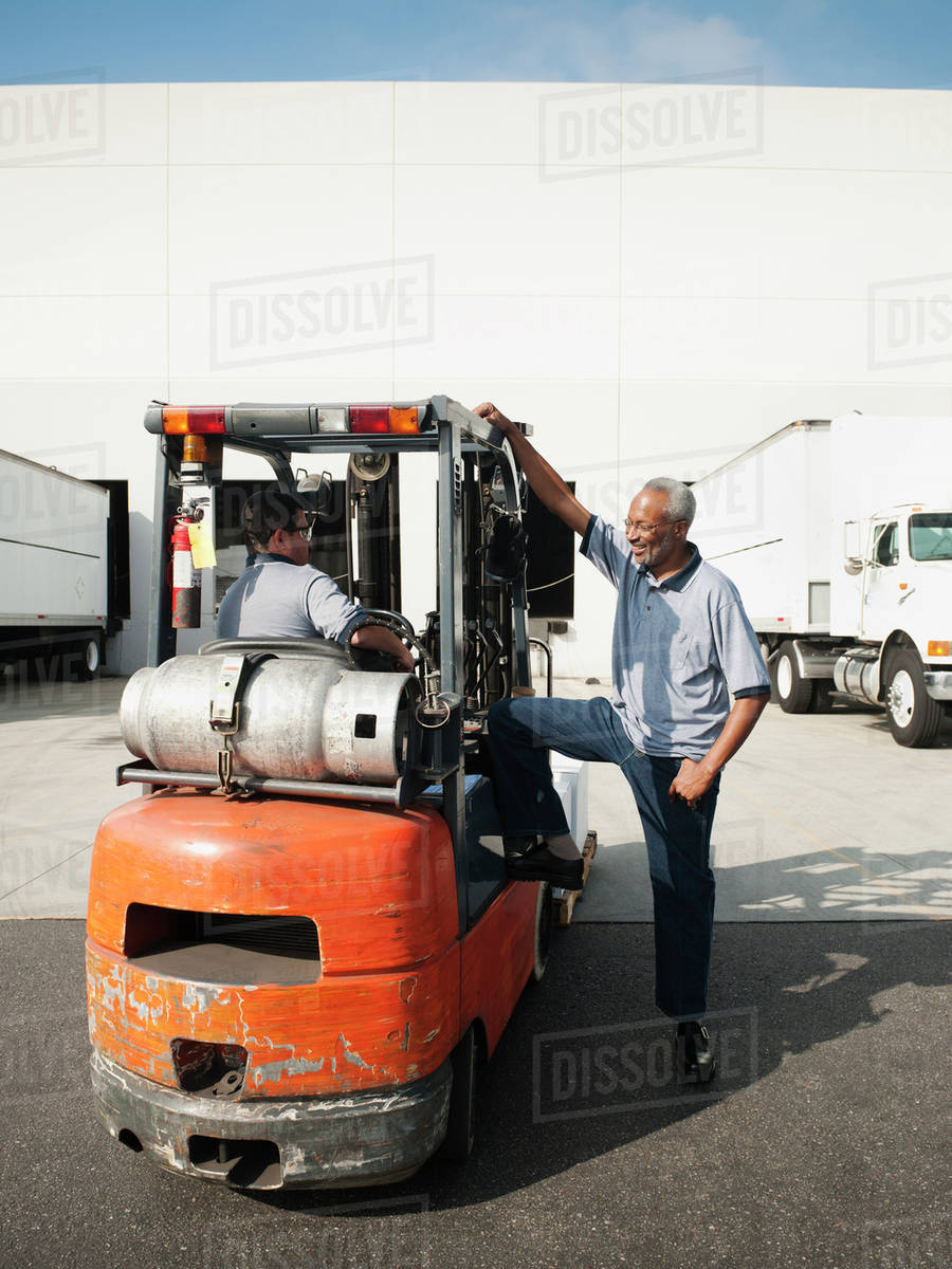 Two men working with forklift - Stock Photo - Dissolve