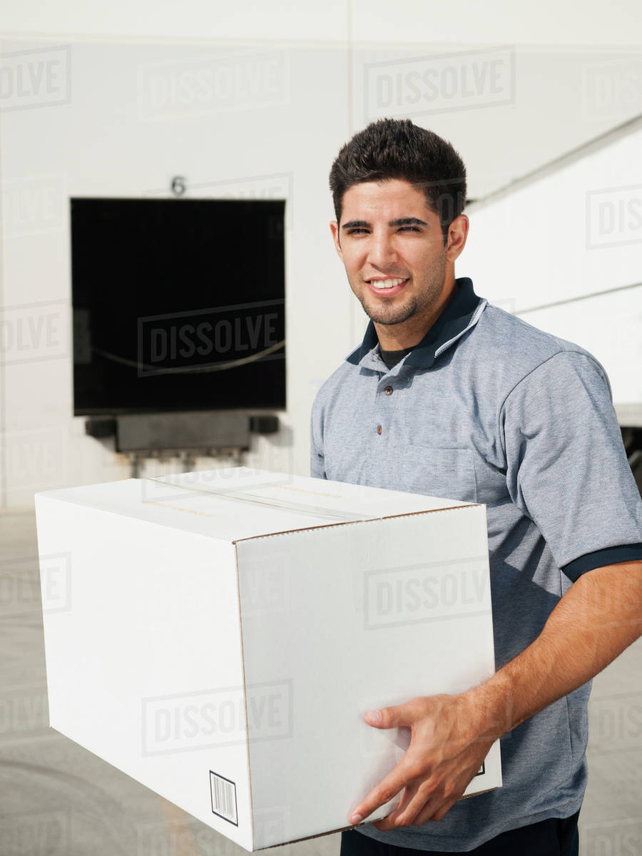 Man carrying box in warehouse - Stock Photo - Dissolve