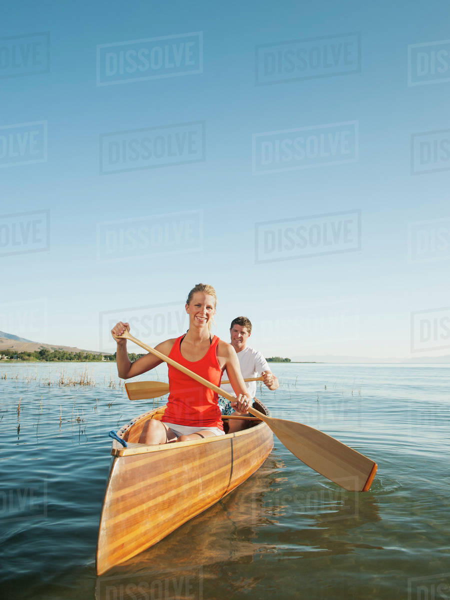 Portrait of two young people paddling canoe - Royalty-free Stock Photo ...