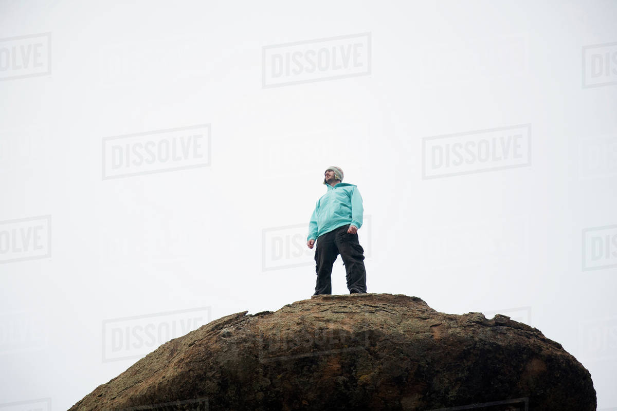 Man standing on rock - Royalty-free Stock Photo | Dissolve