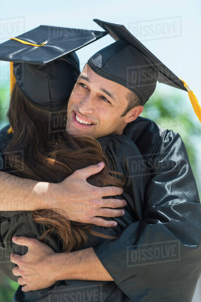 Male and female students embracing on graduation ceremony - Royalty ...