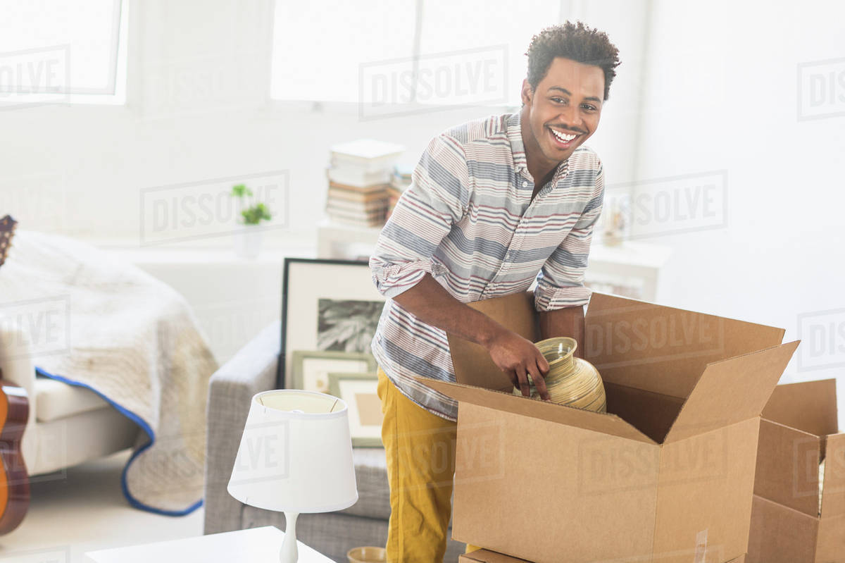Man packing decors into cardboard box - Stock Photo - Dissolve