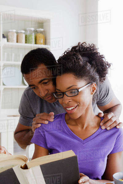Smiling couple reading book together - Royalty-free Stock Photo | Dissolve