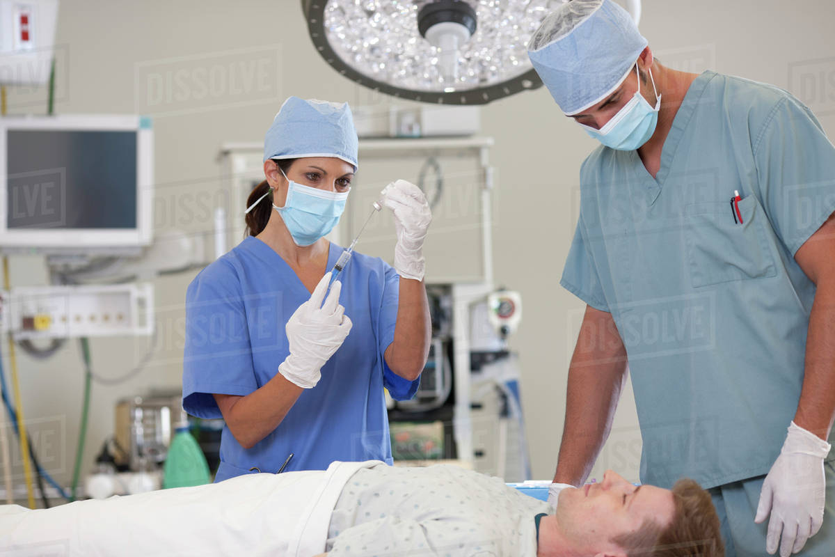 Surgeons preparing patient for surgery - Royalty-free Stock Photo ...