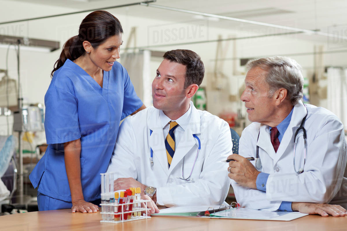 Female surgeon and two male doctors in hospital - Stock Photo - Dissolve
