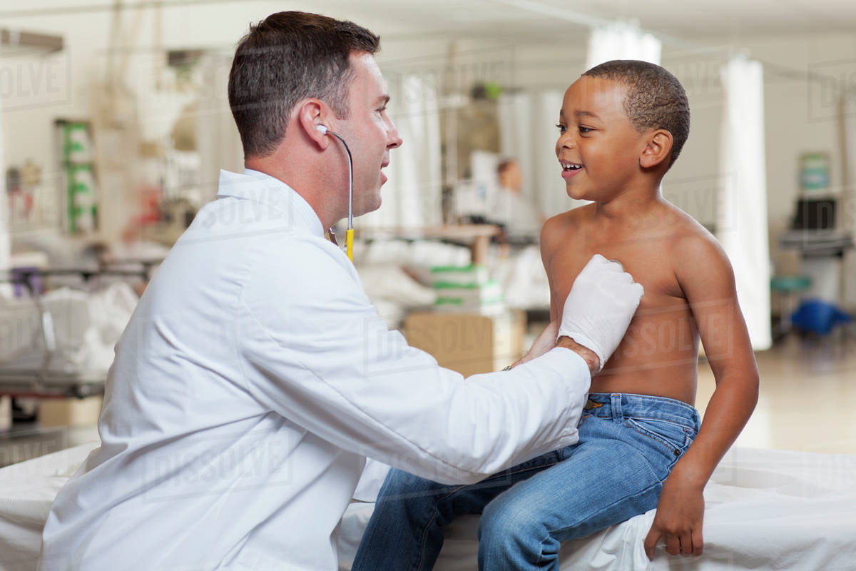 Doctor examining boy (4-5) in hospital - Stock Photo - Dissolve