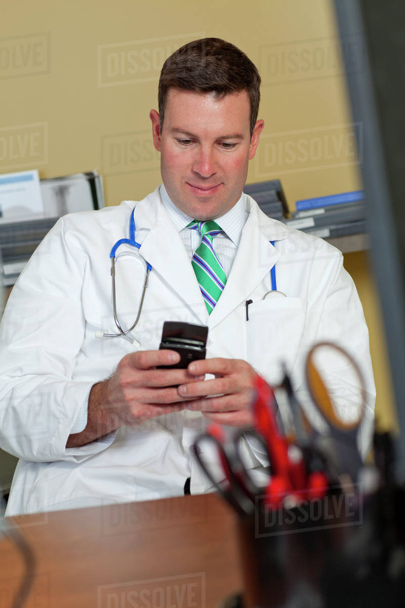Male doctor text messaging - Stock Photo - Dissolve