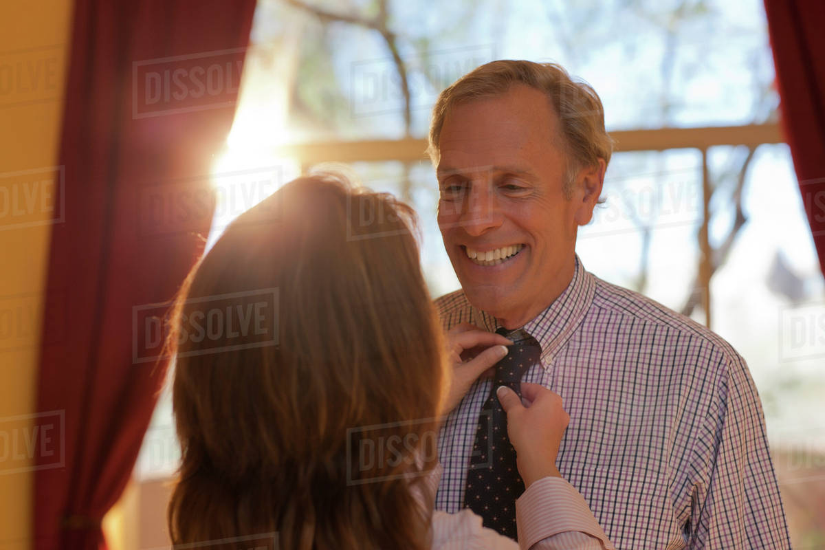 Woman helping man get dressed - Royalty-free Stock Photo | Dissolve