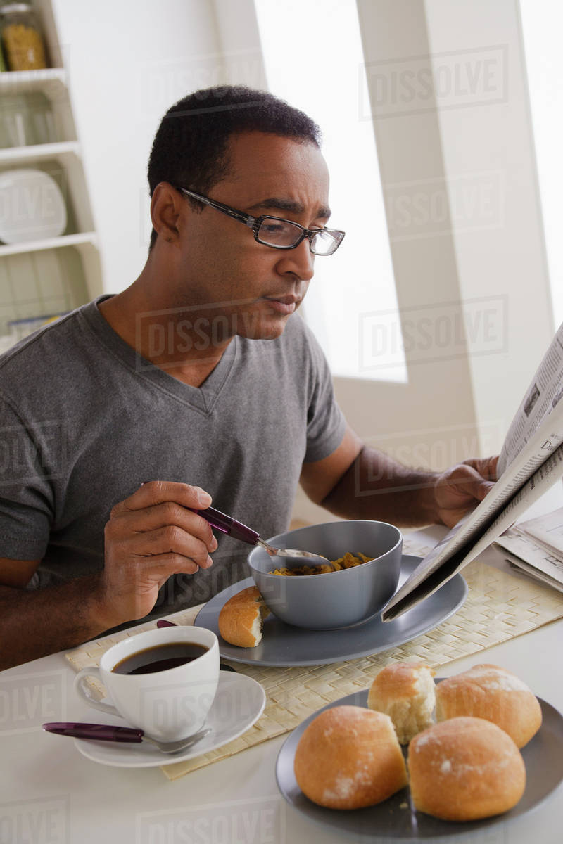 Mature man eating breakfast and reading newspaper - Royalty-free Stock ...