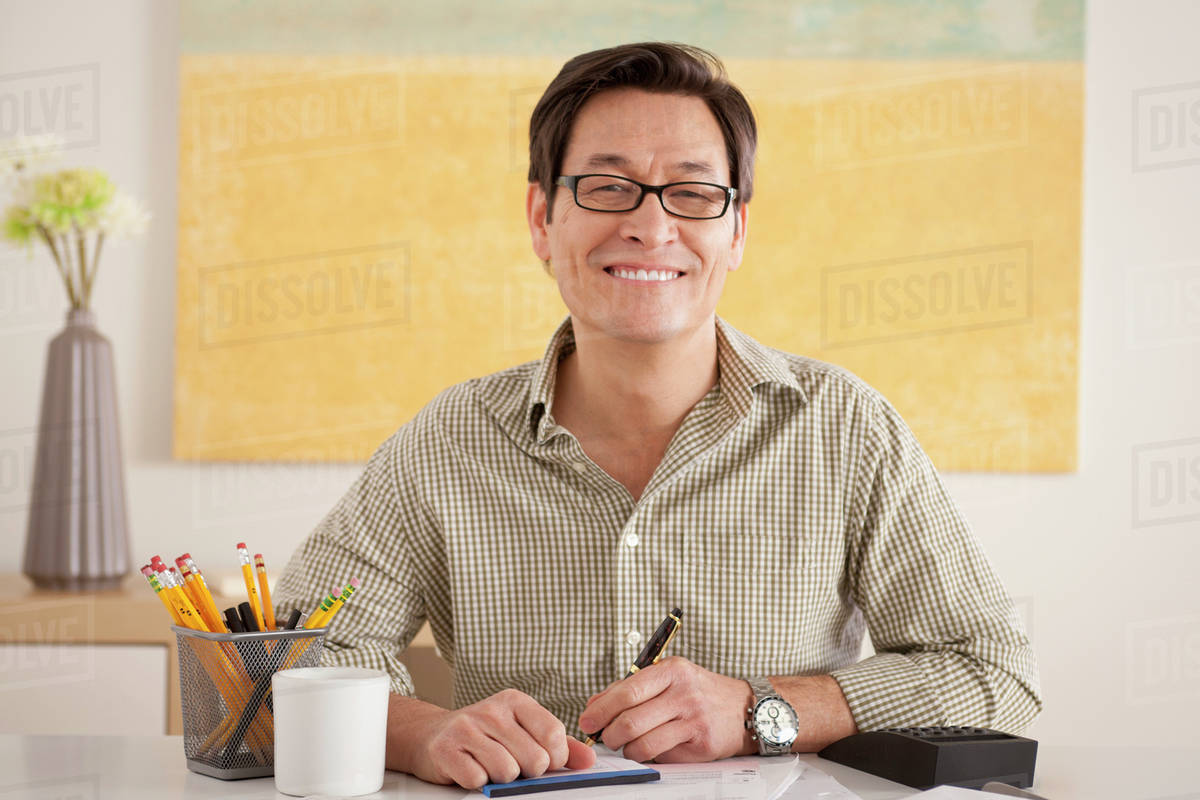 Portrait of man doing paperwork - Stock Photo - Dissolve