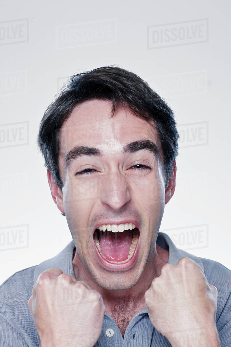 Portrait of excited man, studio shot - Royalty-free Stock Photo | Dissolve