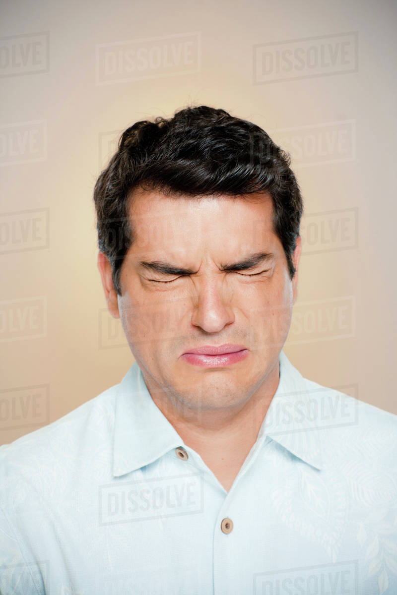 Portrait of man frowning with closed eyes - Stock Photo - Dissolve