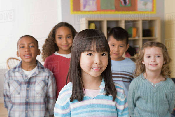 Smiling children (6-7) in classroom - Stock Photo - Dissolve