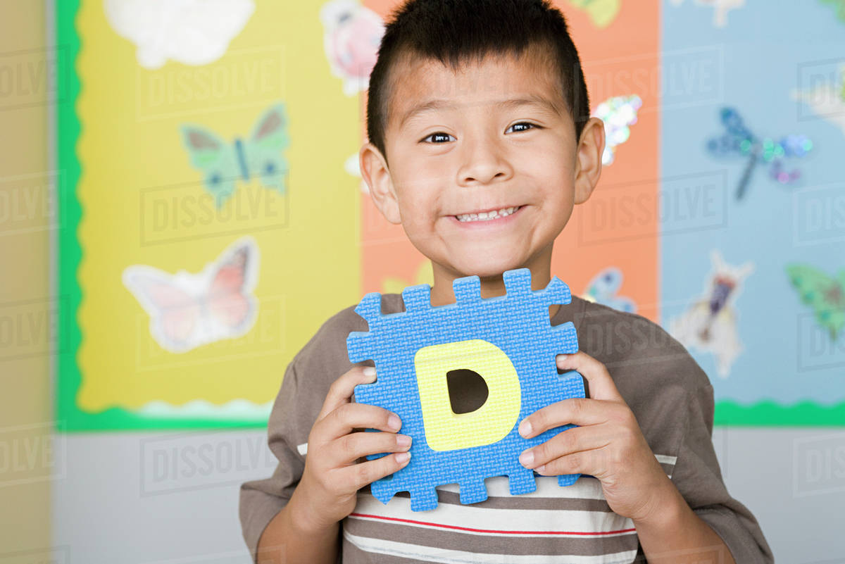 Boy (6-7) holding D letter in classroom - Royalty-free Stock Photo ...