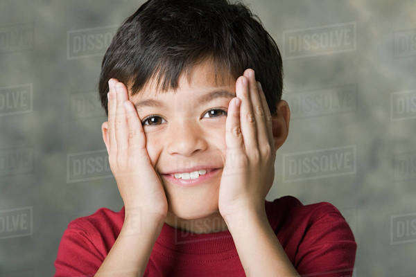 Portrait of smiling boy (8-9) with hands on face, studio shot - Stock ...
