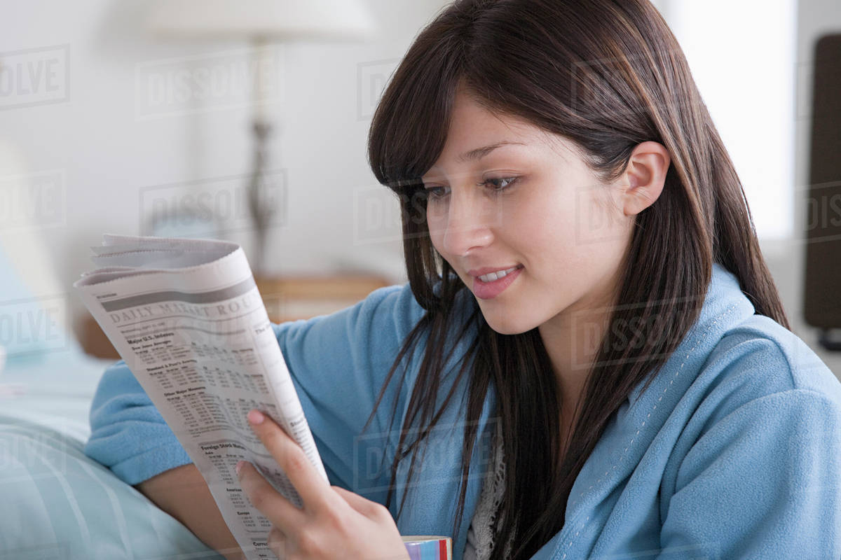 Woman reading newspaper at home - Royalty-free Stock Photo | Dissolve