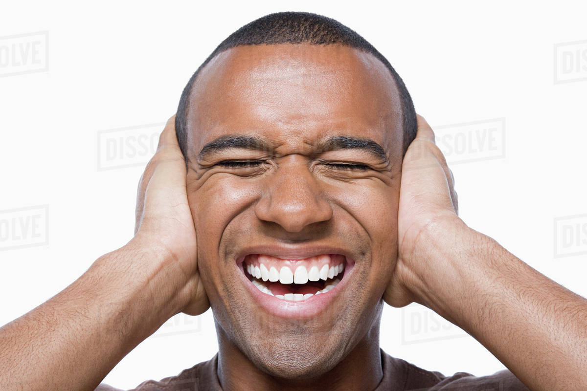 Studio portrait of young man with hands on his ears - Stock Photo ...