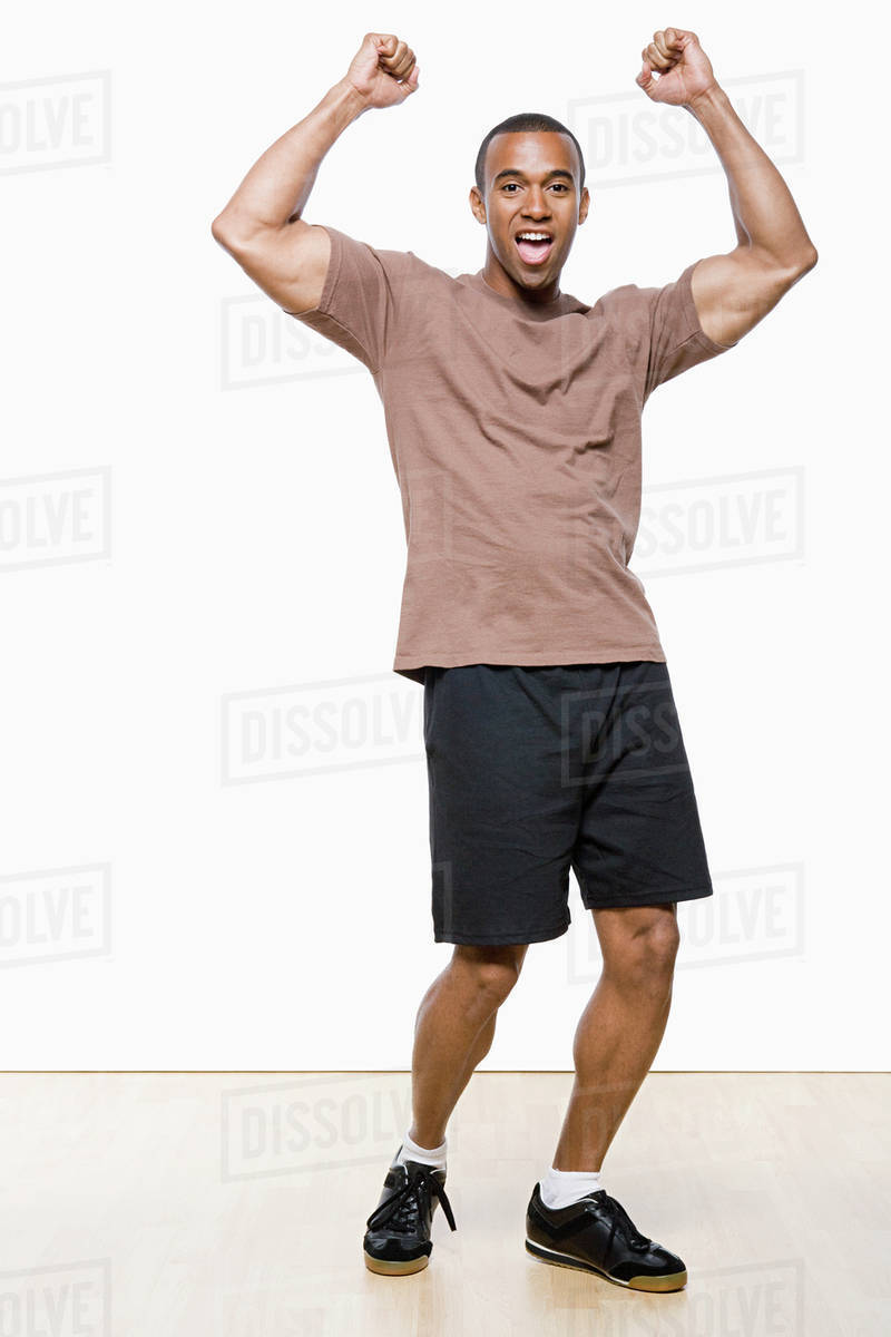 Studio portrait of young man cheering - Royalty-free Stock Photo | Dissolve