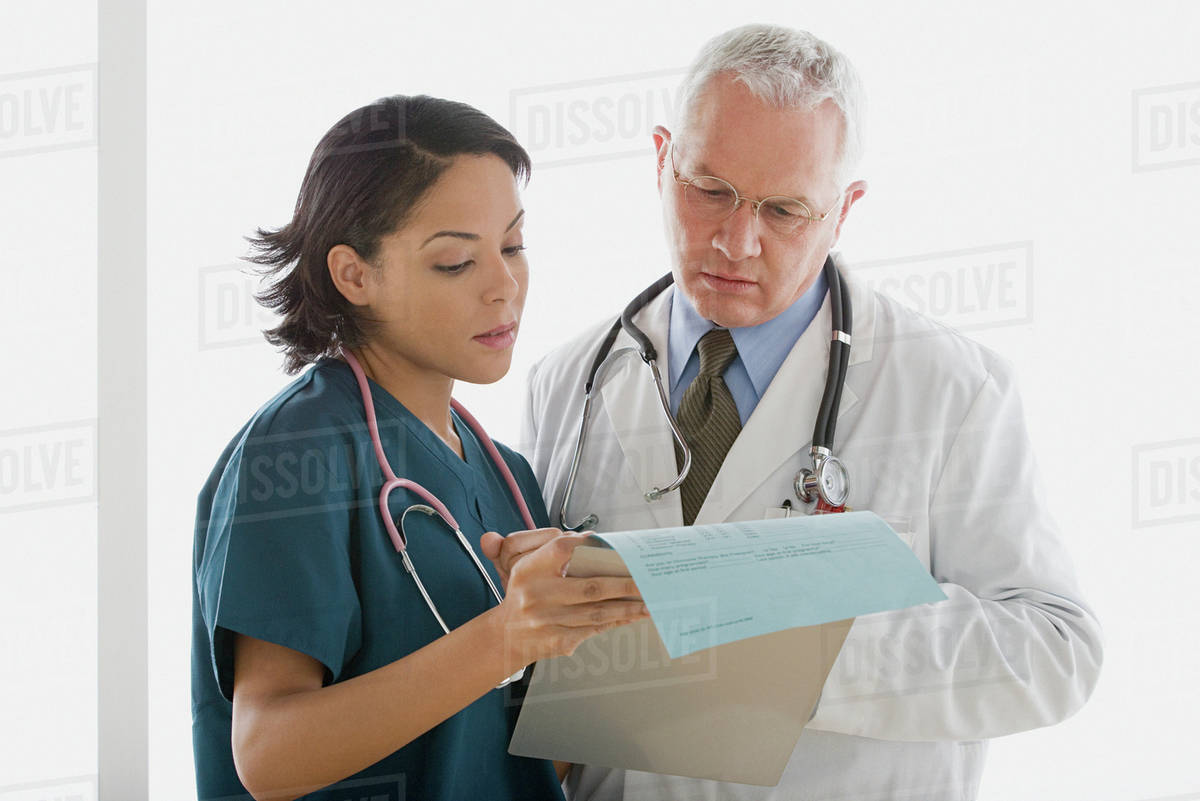 Two doctors reading document - Royalty-free Stock Photo | Dissolve