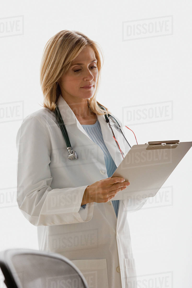 Doctor reading document - Stock Photo - Dissolve