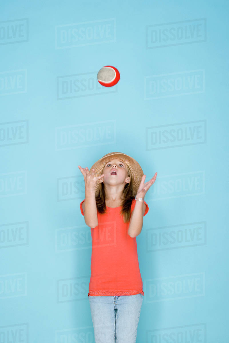 Studio shot portrait of teenage girl throwing ball, three quarter ...