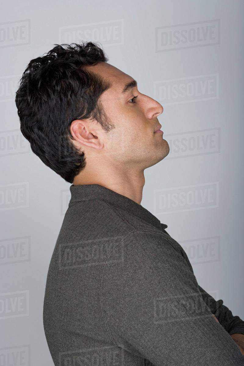Side view of mid adult man with hands on hip, head and shoulders ...