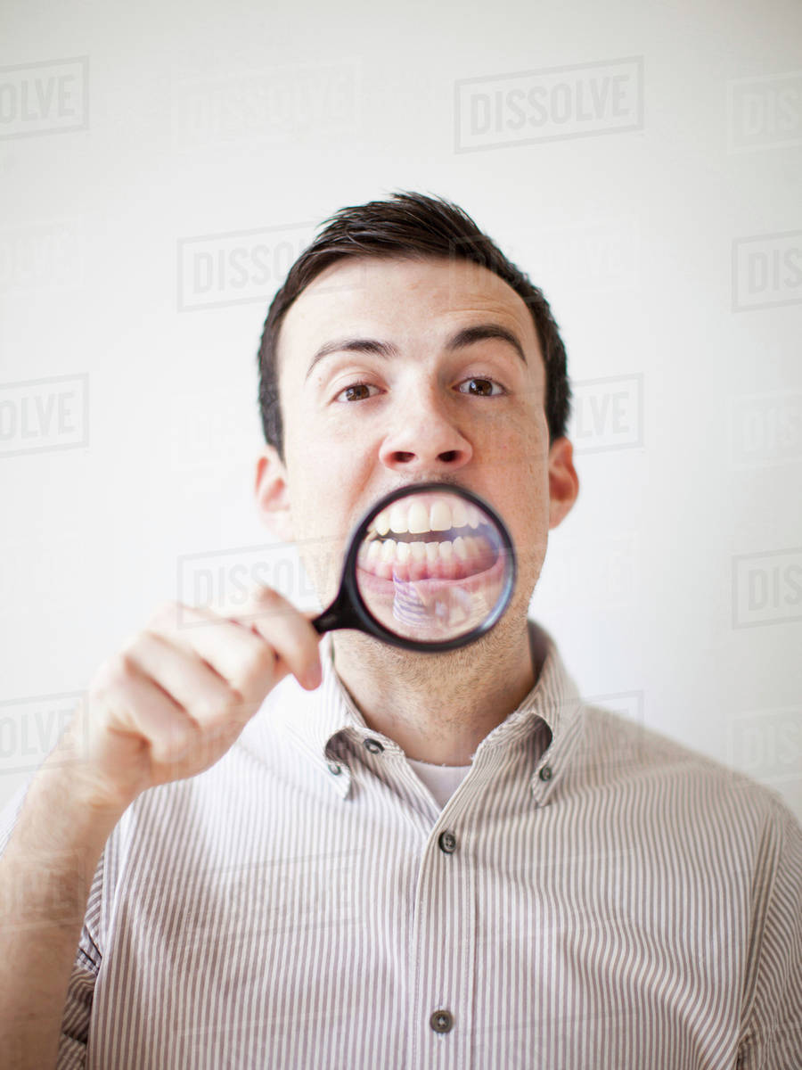 Man looking standing looking through magnifying glass - Royalty-free ...