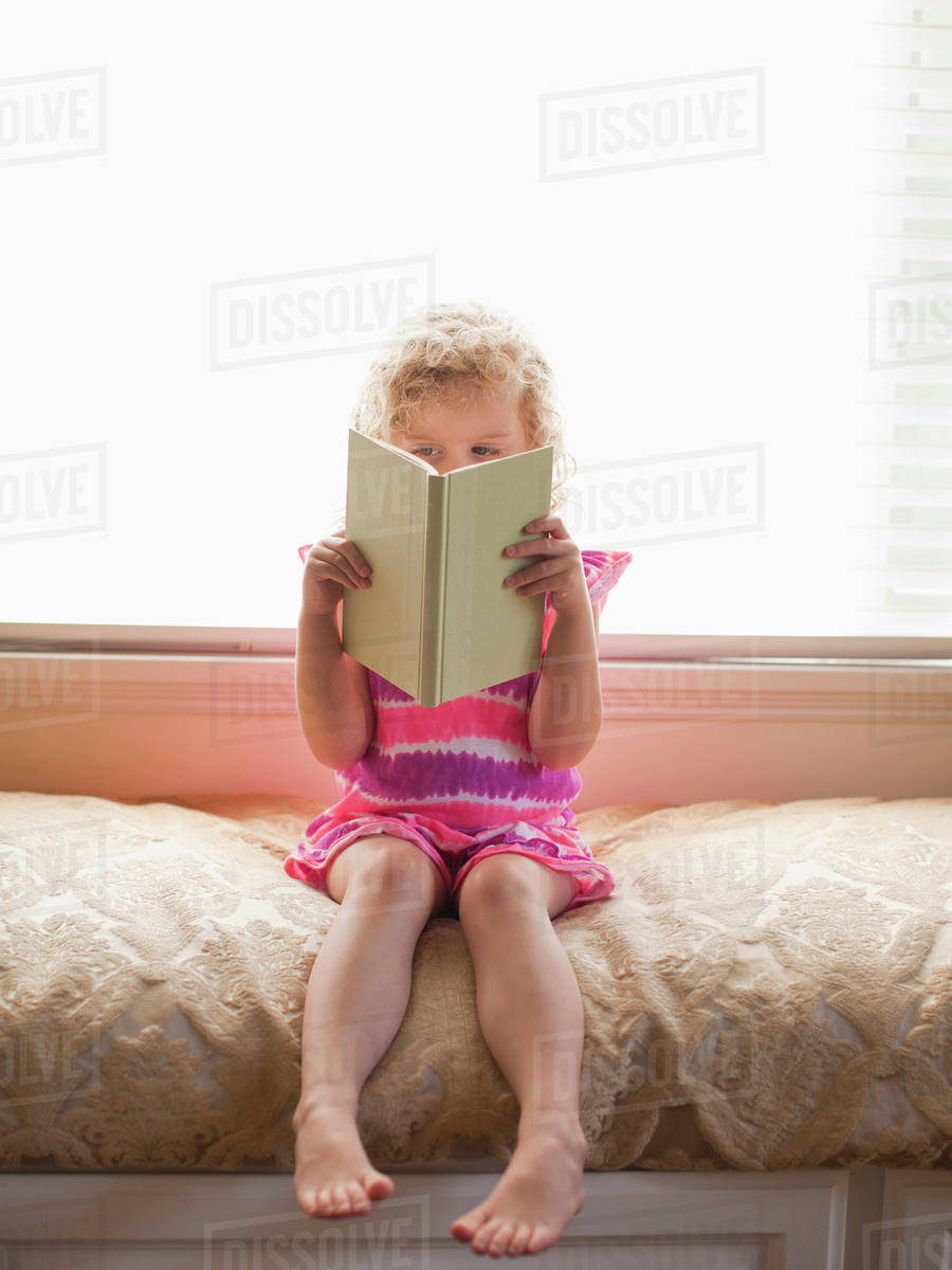 Girl sitting and reading book - Royalty-free Stock Photo | Dissolve