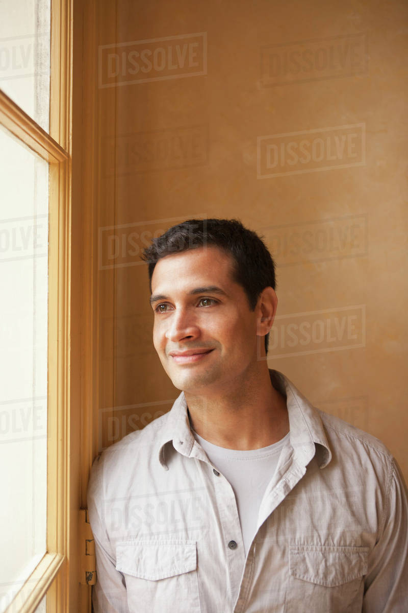 Portrait of man looking out window - Stock Photo - Dissolve