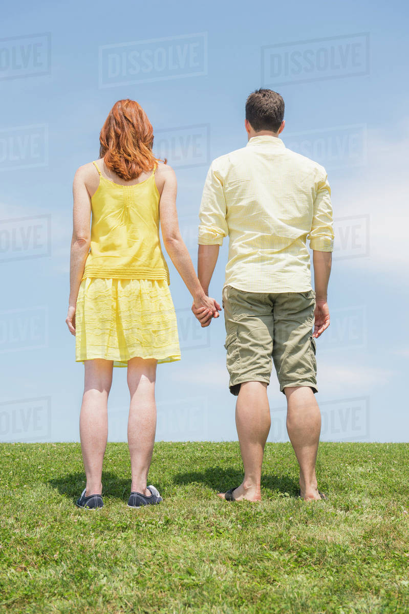 Couple standing on meadow - Royalty-free Stock Photo | Dissolve