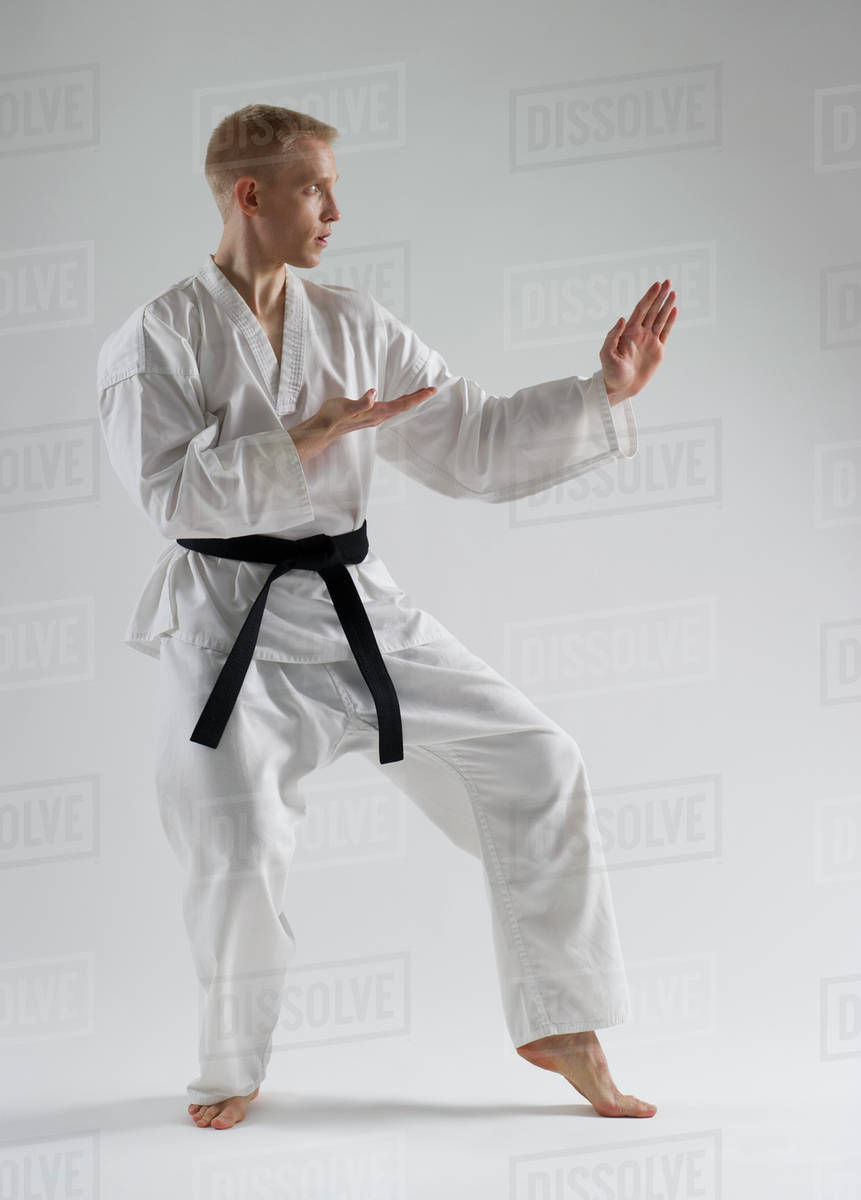 Young man performing karate stance on white background - Royalty-free ...