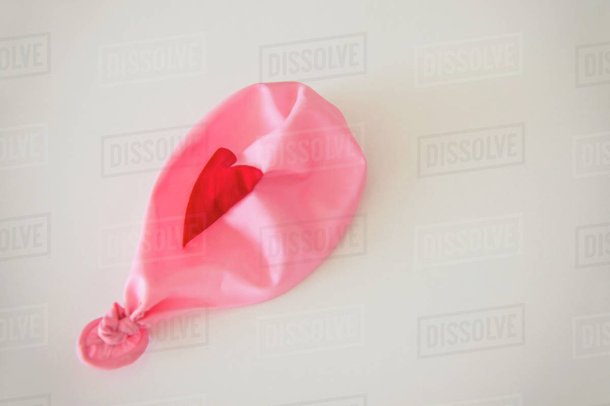 Studio Shot of deflated pink balloon - Stock Photo - Dissolve