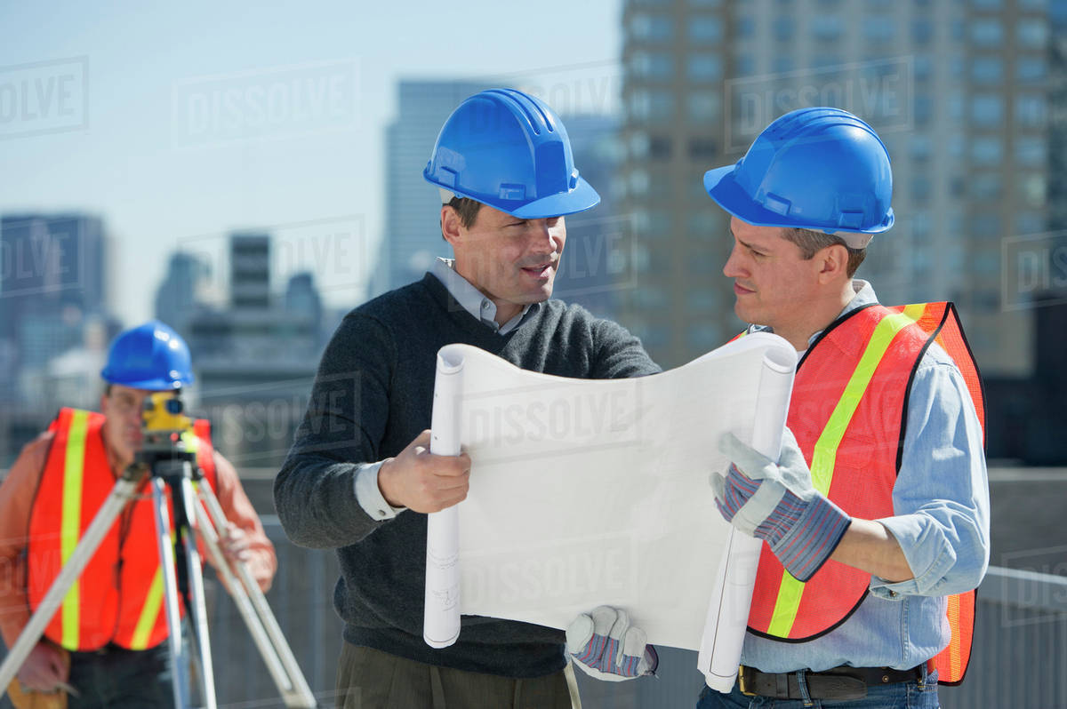 USA, New Jersey, Jersey City, construction workers reading blueprint ...