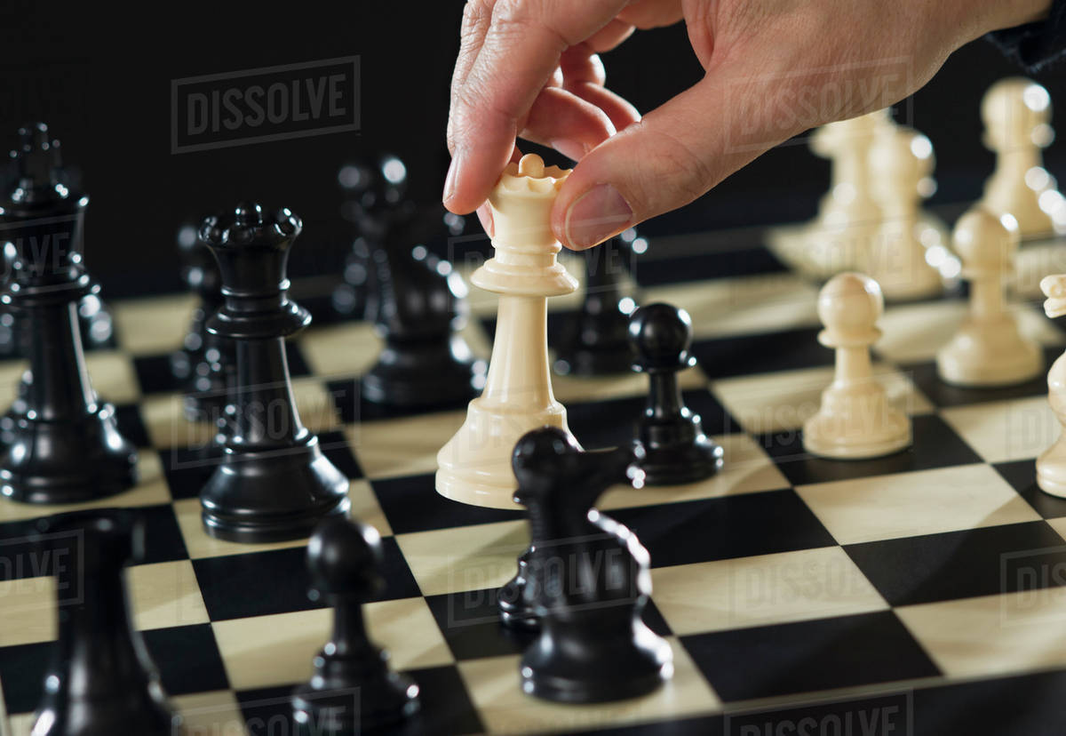 Close-up of man's hand playing chess - Stock Photo - Dissolve