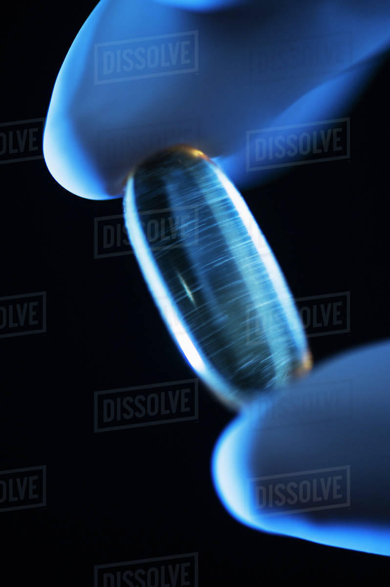 Studio shot of hand holding capsule - Royalty-free Stock Photo | Dissolve
