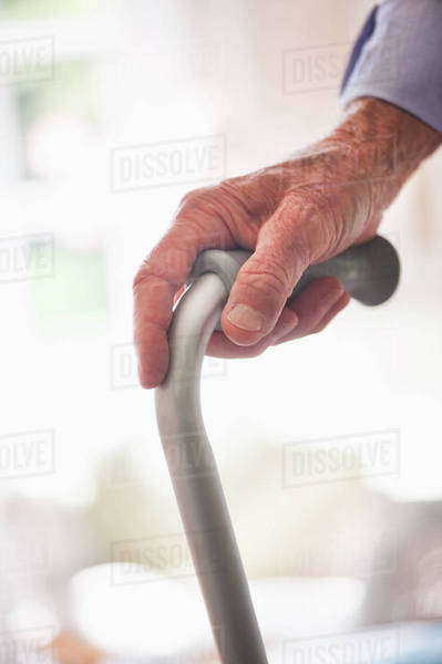 Wrinkled hand holding walking stick - Royalty-free Stock Photo | Dissolve