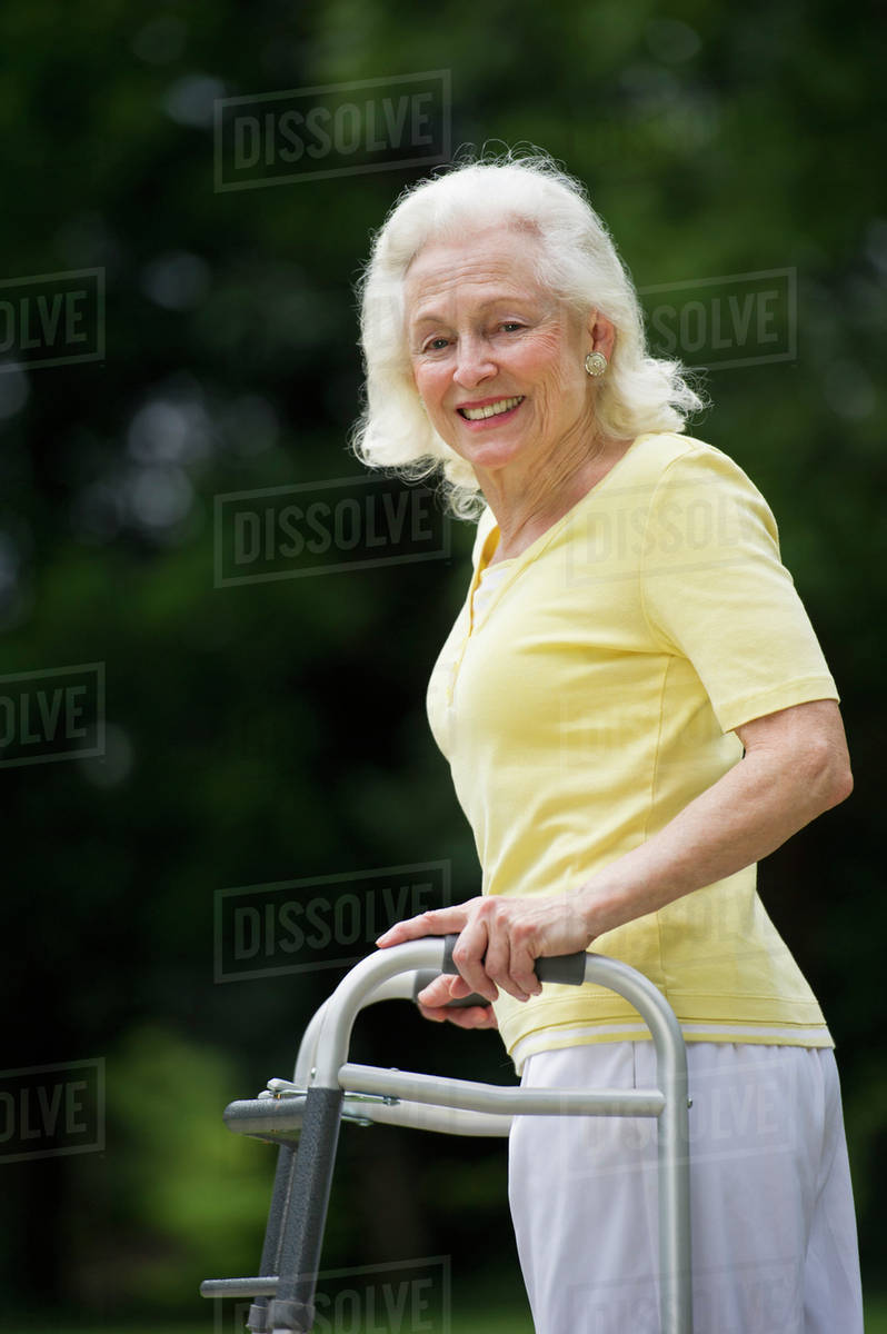 Senior woman walking with walker - Royalty-free Stock Photo | Dissolve