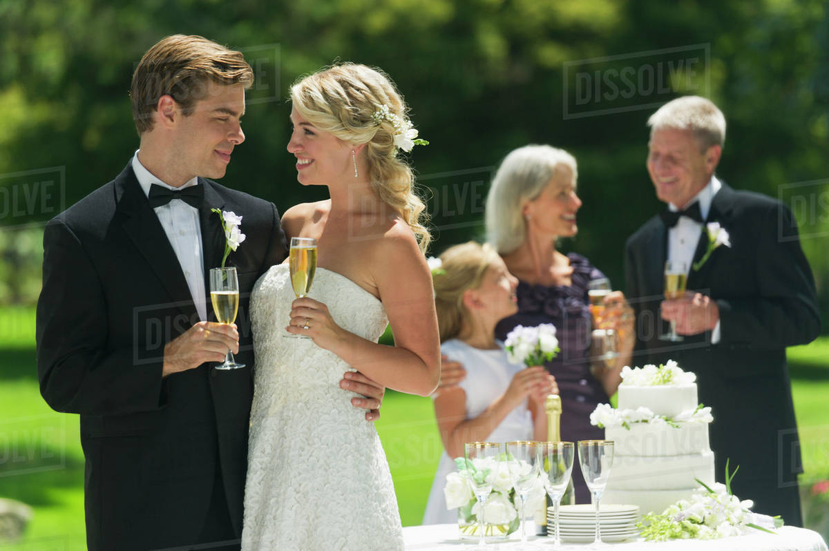 Bride and groom at wedding reception, people in background - Stock ...