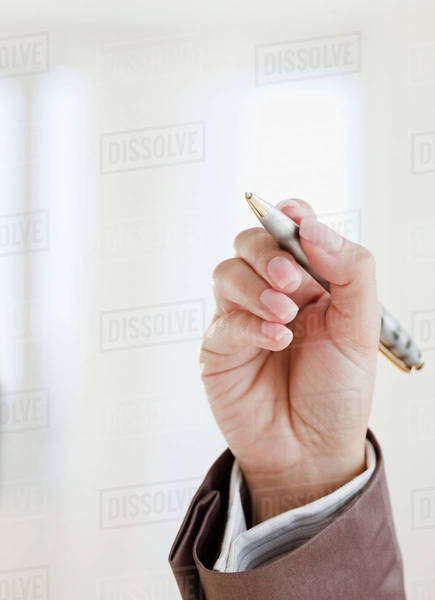 Close up of woman's hand holding pen - Stock Photo - Dissolve