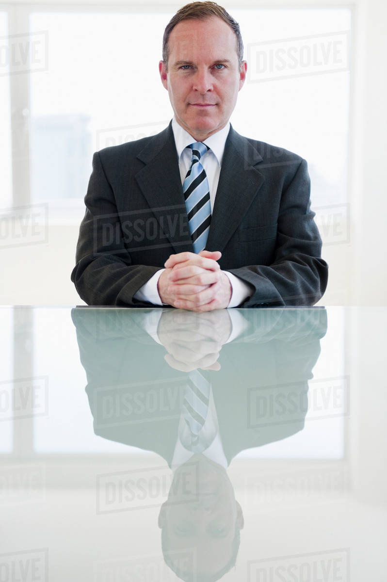 Businessman sitting at table - Royalty-free Stock Photo | Dissolve