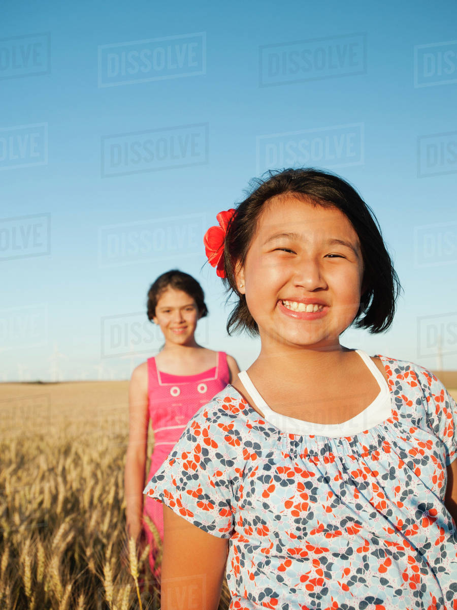 Girls (10-11, 12-13) standing in whet field - Royalty-free Stock Photo ...