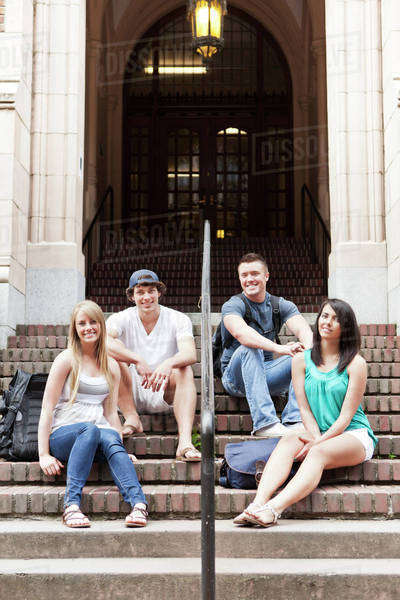 Portrait of four college students sitting on steps - Royalty-free Stock ...