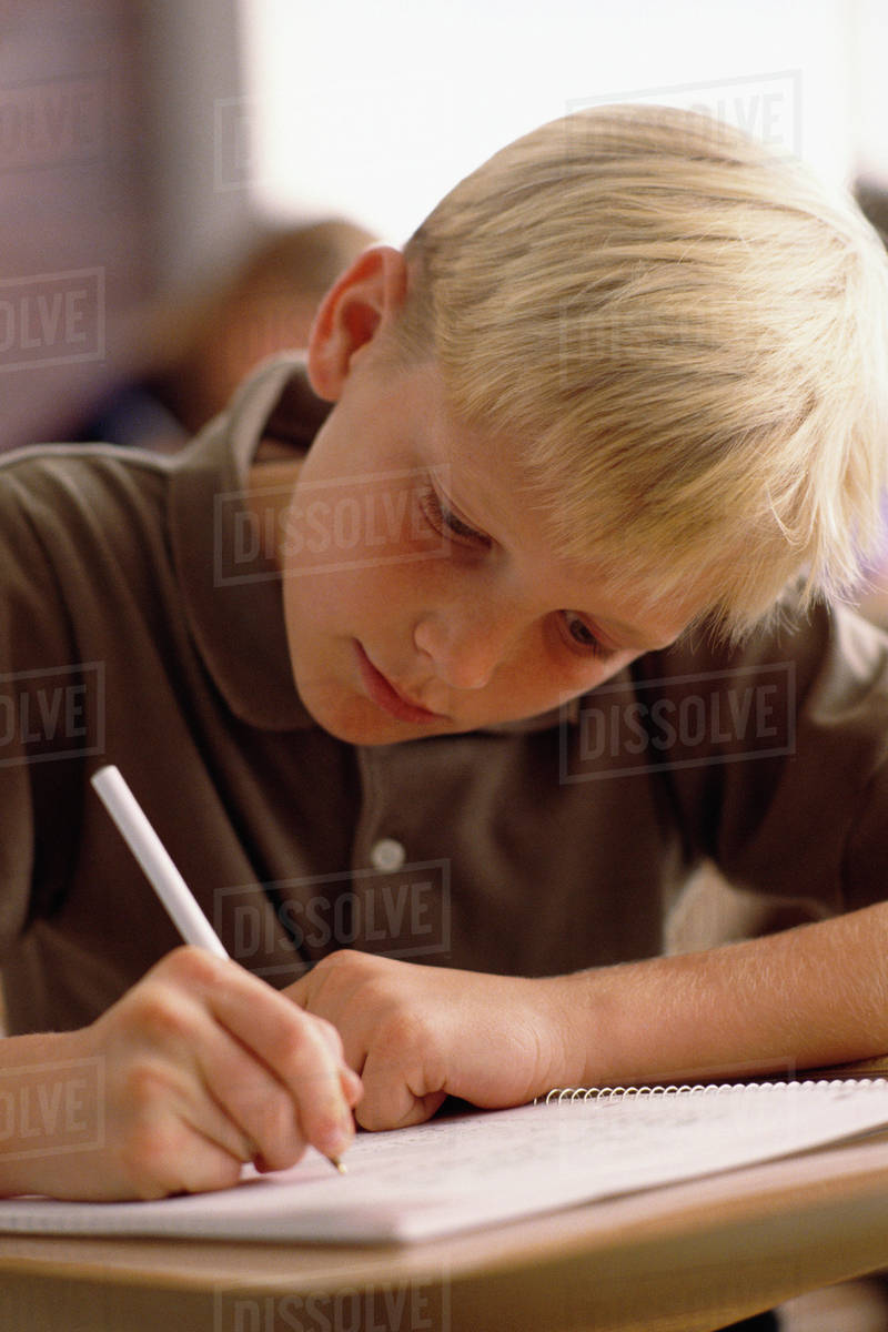 Boys working at desk in classroom - Royalty-free Stock Photo | Dissolve