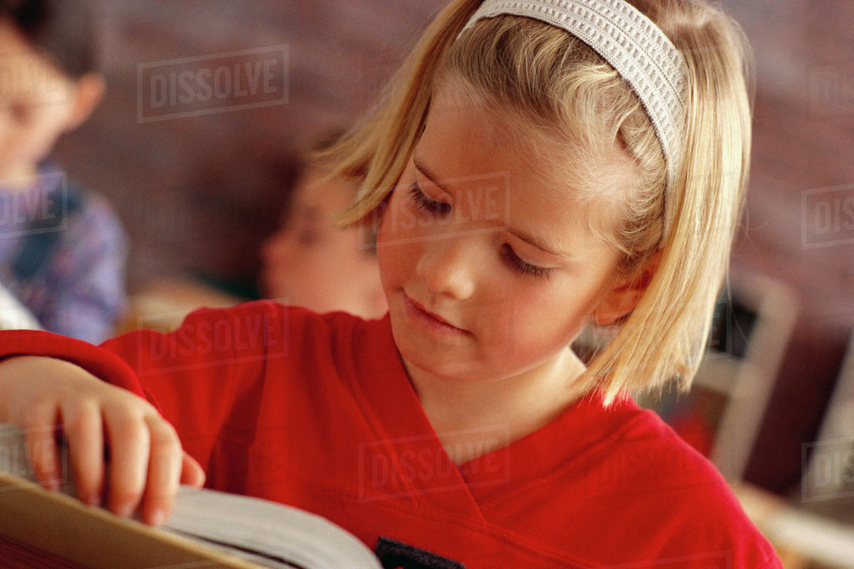 Student reading book in classroom - Royalty-free Stock Photo | Dissolve