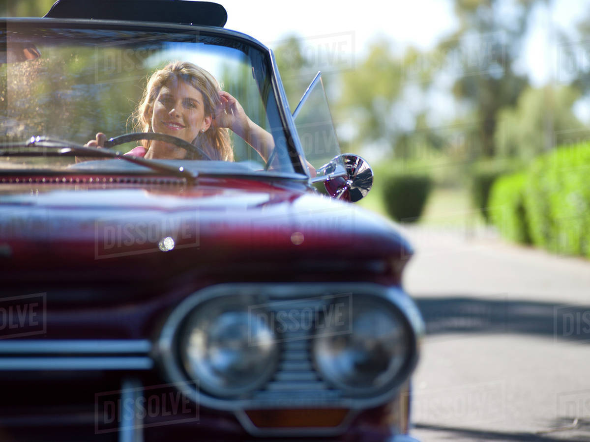 Young woman driving classic's car - Stock Photo - Dissolve