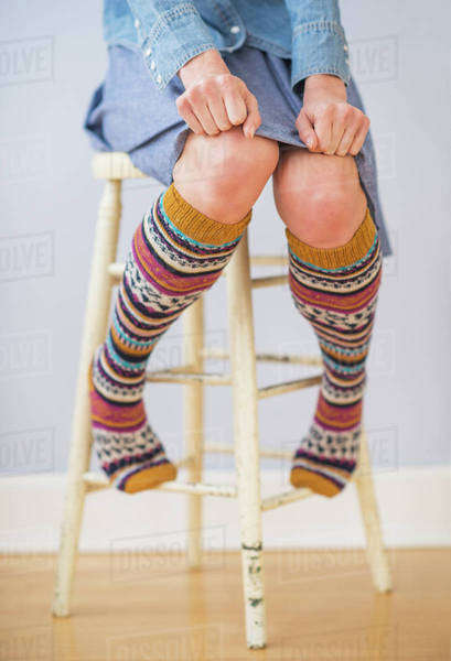 Studio Shot, Low section of woman sitting on stool wearing striped ...