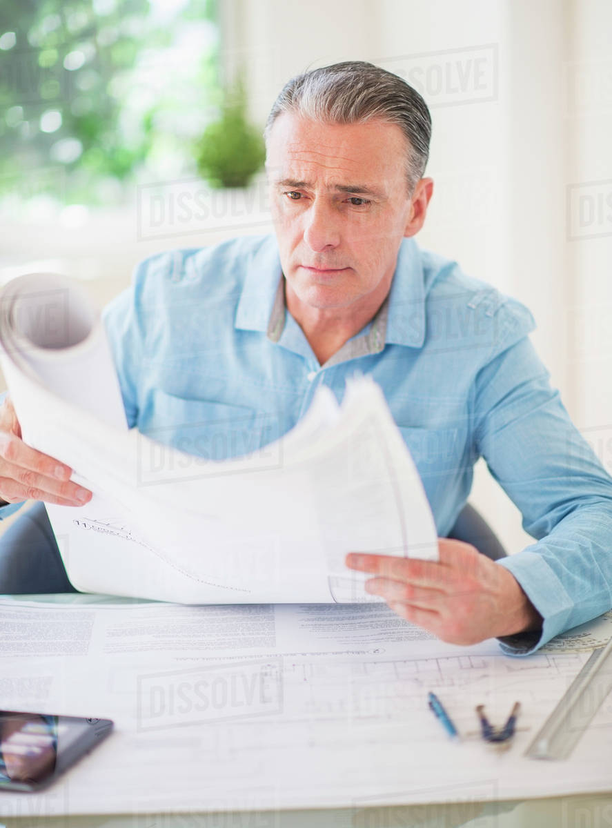Portrait of man looking at blueprints in office - Royalty-free Stock ...