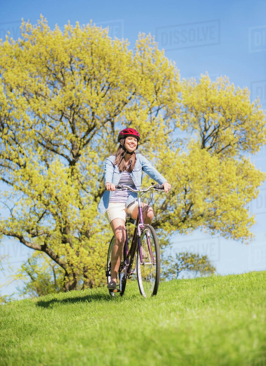 Mid adult woman riding bicycle - Stock Photo - Dissolve