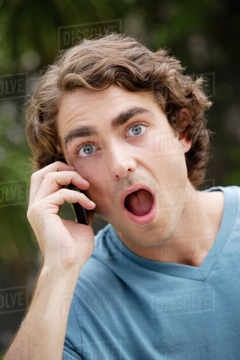 Portrait of young man talking on phone, with facial expression ...