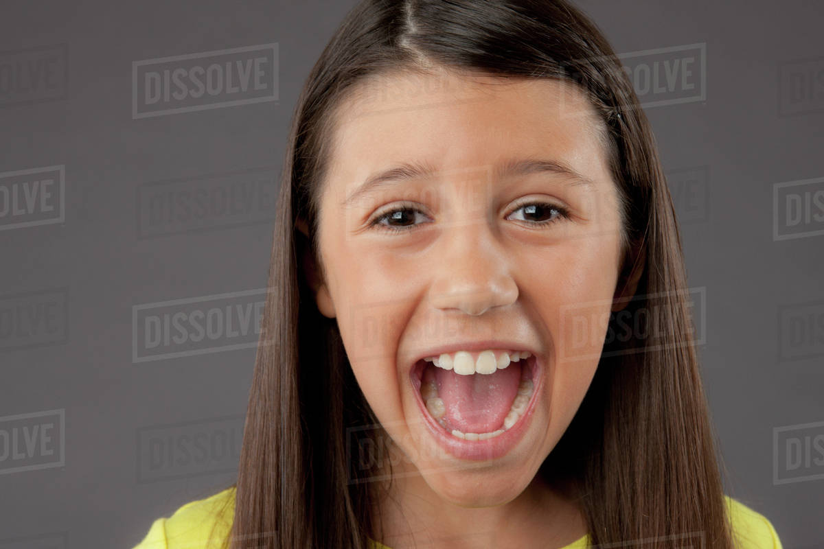 Portrait of screaming girl (8-9), studio shot - Stock Photo - Dissolve